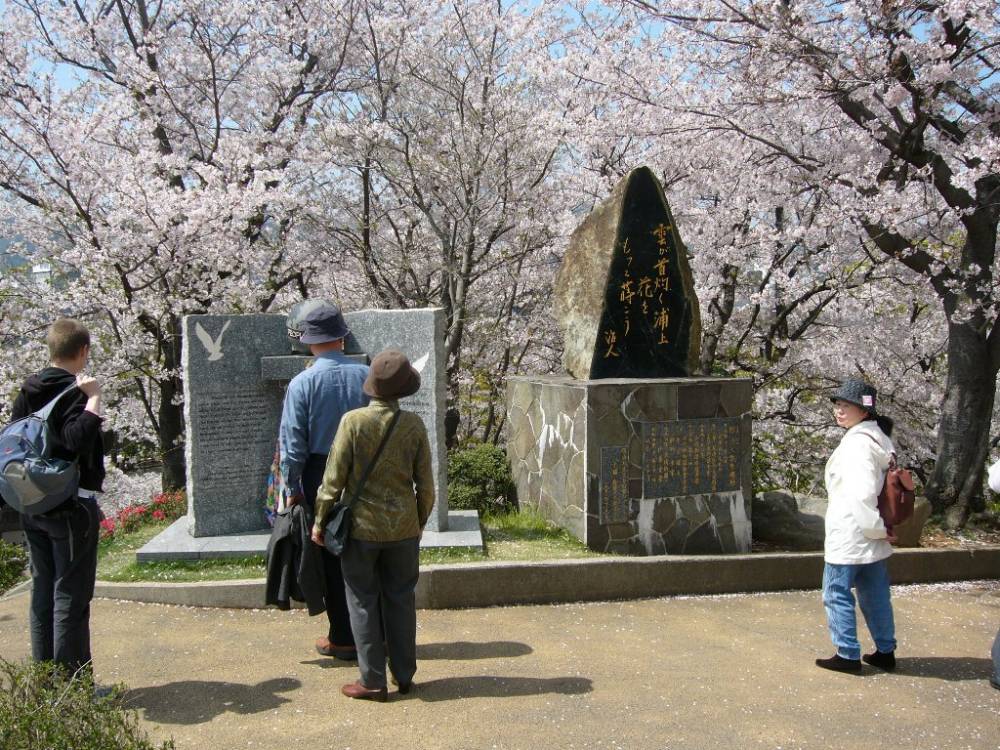 Stone monuments and beautiful pink sakura in Nagasaki Peace Park at ...